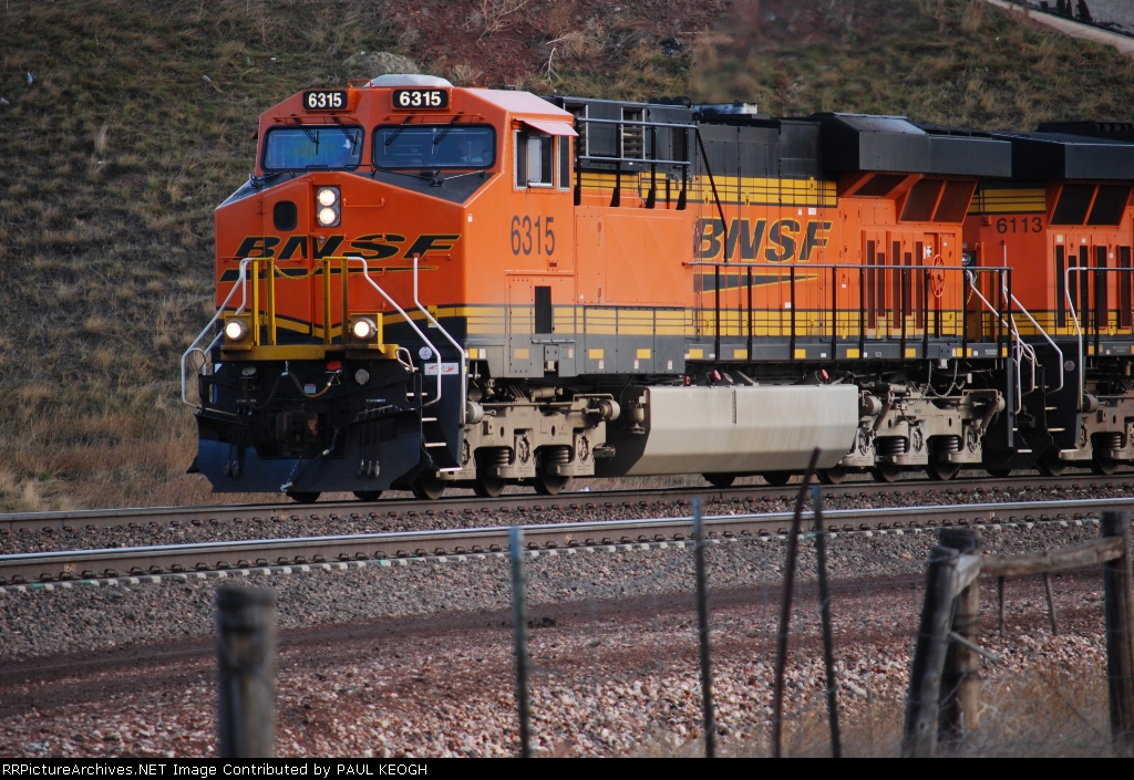 Zoom in shot of BNSF 6315 as she makes the Y turn out of Donkey Creek yard and climbs the grade ...